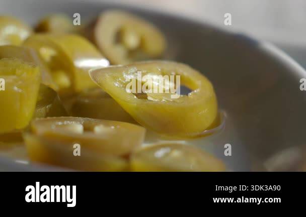 Sliced jalapeno peppers sit on a white plate ready to eat Stock Video ...