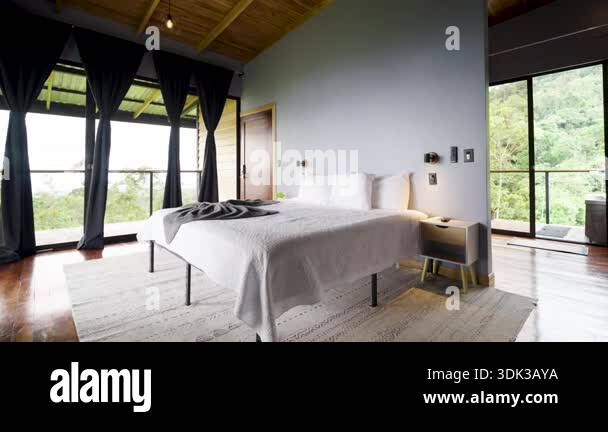 Modern and stylish hotel bedroom interior with large windows and a ...