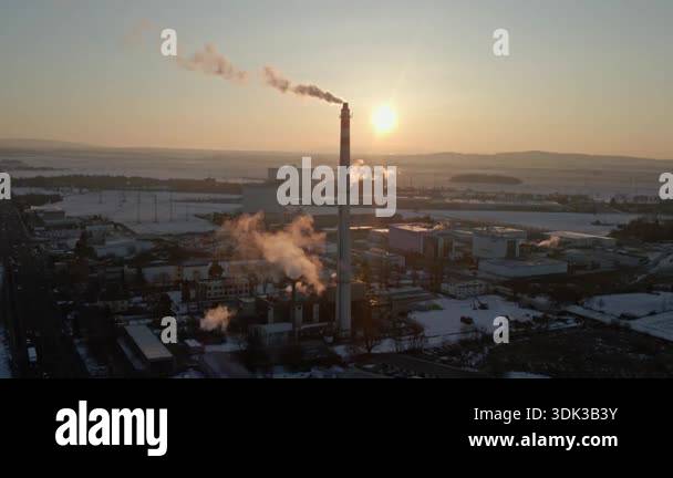 Aerial view of a factory chimney releasing smoke into the air during a ...
