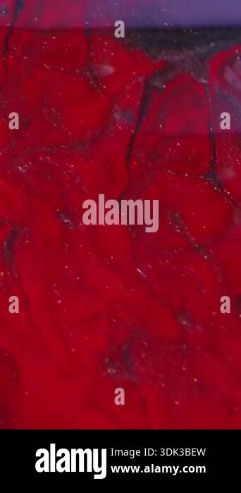 Vertical video. Color mix. Shiny texture. Defocused red purple paint ...