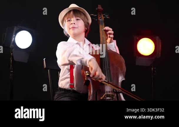 Cute little boy playing violoncello on stage, low angle view Stock ...