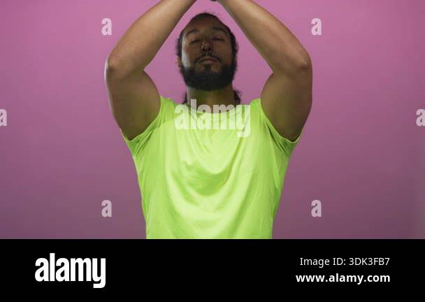 Man with bearded face pressing palms together in prayer pose wearing ...