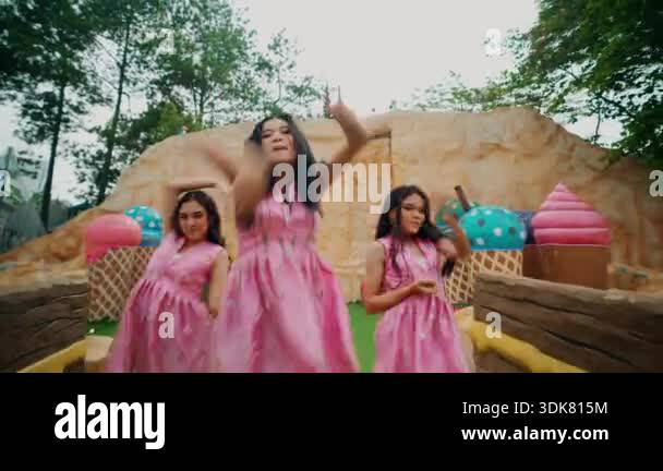 Three female dancers in pink dresses striking confident poses and ...