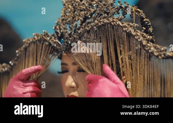 An artistic performance piece where a gold-masked dancer touches and ...