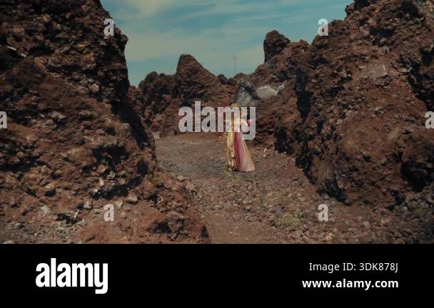 A wide shot of a fashion model spinning around, letting her gold dress ...