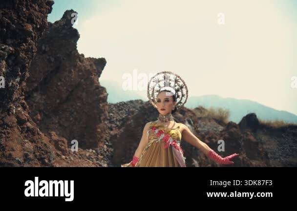 Beautiful female model in a gold couture gown and ornate crown holding ...