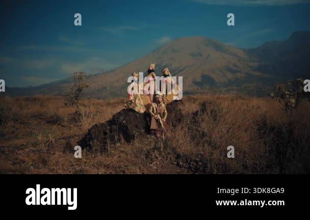 A wide, cinematic shot of a group of four traditional dancers in ...