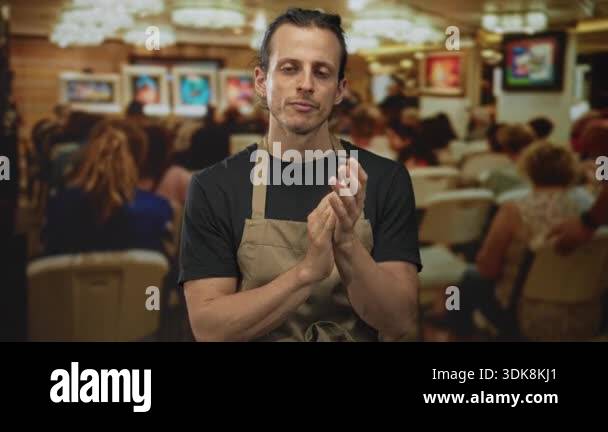 Man clapping hands while seated in a building gallery during an indoor ...