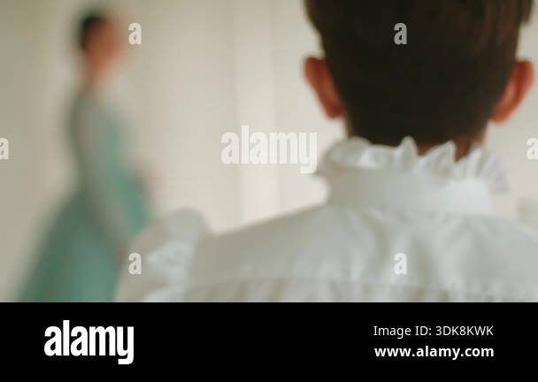 Cinematic over-the-shoulder view. A man in the foreground (out of focus ...