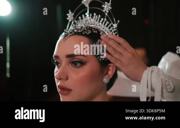Extreme close up of hands adjusting a silver crown on a woman's ...