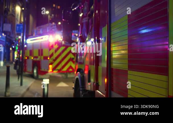 Fire truck standing on residential city street at night with emergency ...