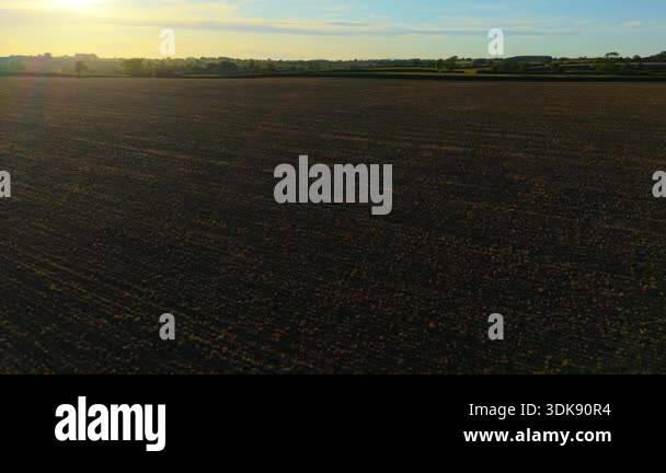 Clean arable land with freshly cultivated field in evening light ...