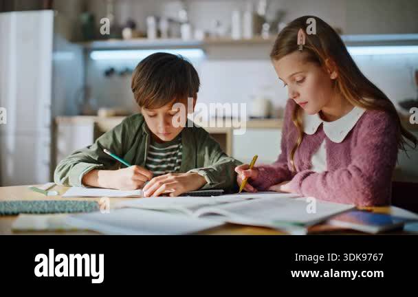 Clever children completing homework modern home desk closeup. Focused ...