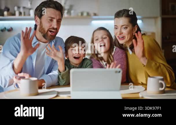 Family parents children videocalling tablet sitting home kitchen ...