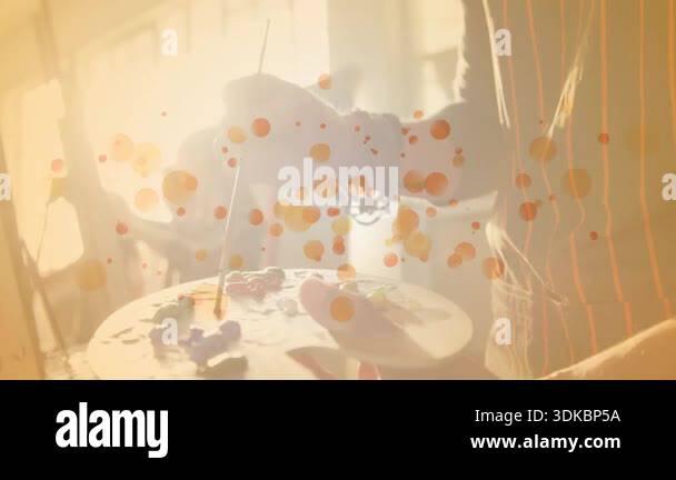 Artist dipping brush into red paint making droplets while mixing ...