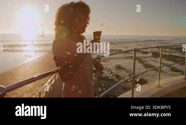 Woman leaning on metal railing overlooking ocean in travel ad while ...