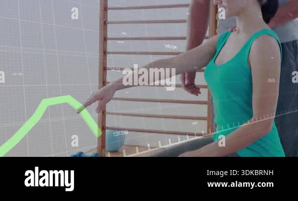 Woman raising arm on exercise ball while trainer guiding posture ...