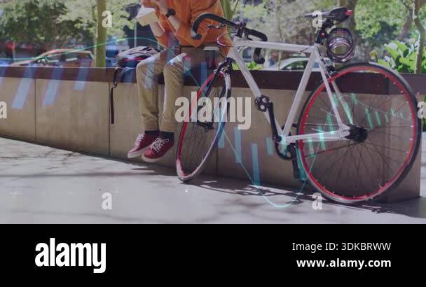 Cyclist settling on ledge after ride and eating sandwich during break ...