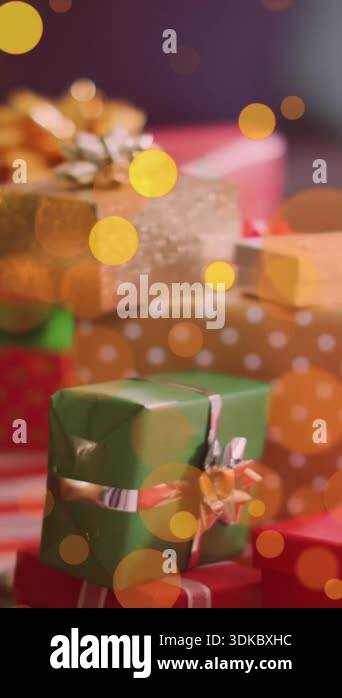 Animation of golden dots stars falling over presents and christmas tree ...
