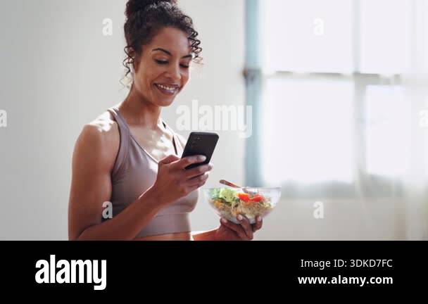 Video of athletic woman eating a healthy fruit bowl while using her ...