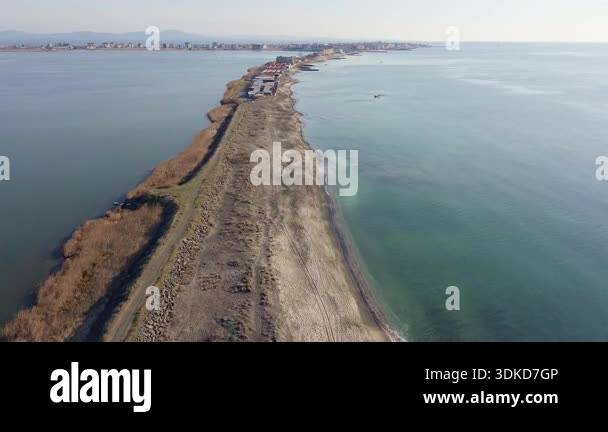 Birds eye view of narrow empty quiet beach with dry sand right and ...