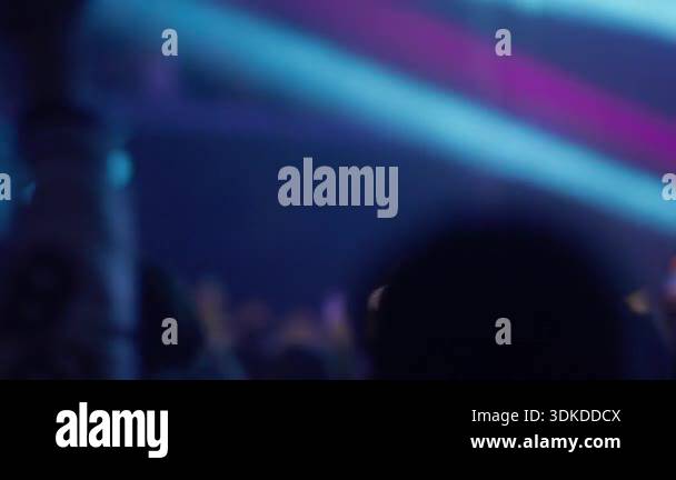 A slow-motion video of a person clapping in a crowd at a concert or ...