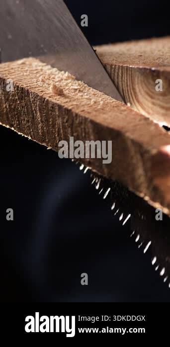 Professional hand saw with sharp teeth cutting through wooden timber ...