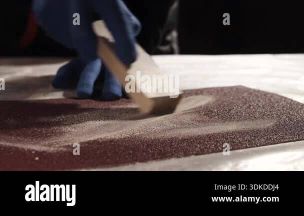 Sanding a piece of wood using sandpaper in carpentry workshop. Close-up ...