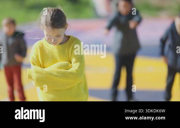 Young lonely girl feeling sad and left out while other children play in ...