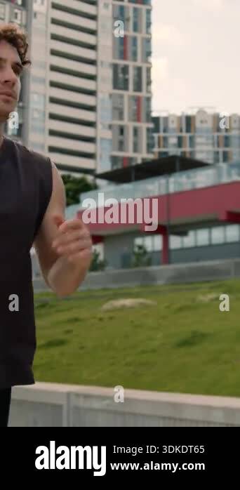 Focused Caucasian man running in city preparing for competition ...