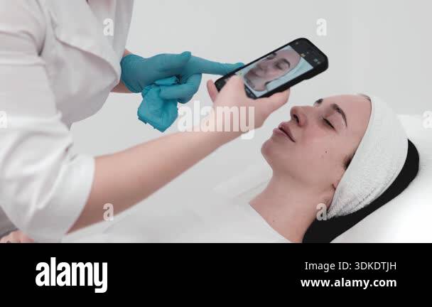 A healthcare professional taking a photo of a patients face with a ...
