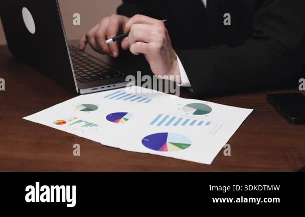 Person analyzing graphs on paper at desk Stock Video Footage - Alamy