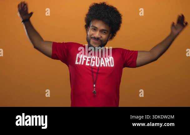 Man smiling lifeguard holding head orange background african american ...