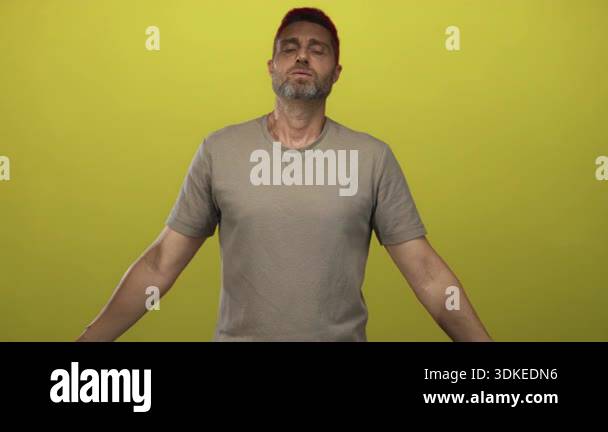 Man pressing fingers into ears in studio against lime green background ...