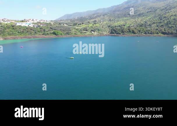 Tourists on catamarans riding on Kournas lake in Crete. 4K drone travel ...