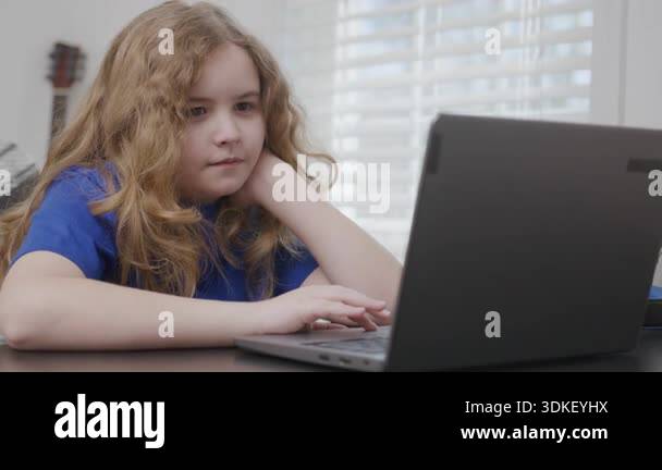 Child typing on laptop keyboard. Child focused on laptop screen. Child ...