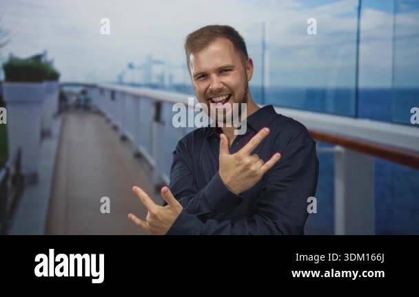 Man in navy shirt pointing finger gun gesture on cruise ship deck ...