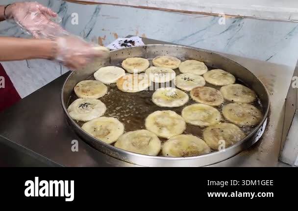 Chinese meat bread fried in a pan are thin and large, which have gone ...