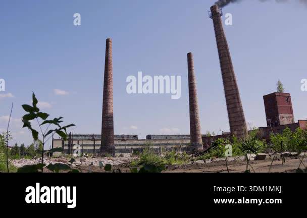 Demolition of old industrial brick pipe at the factory. Destruction and ...