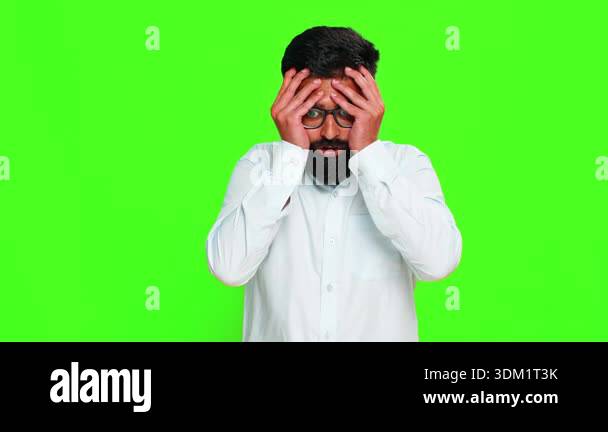 Indian man covers face with hands in tense motion expressing panic ...
