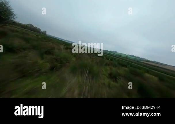 FPV drone low pass over lush green wetland and Eye Brooke reservoir ...