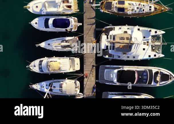 Aerial top down view of a wooden finger pier with motor yachts, a ...