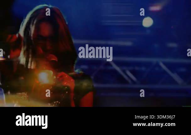 With lights shifting on stage singer stepping holding mic and engaging ...