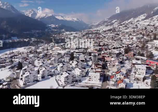 Drone aerial view of a picturesque alpine town covered in snow during ...