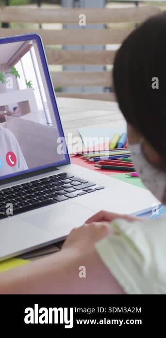 Animation of heart icons over girl in face mask using laptop on video ...