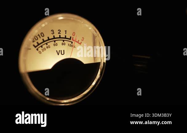 Backlit analog VU meter with a fluctuating needle measuring sound ...