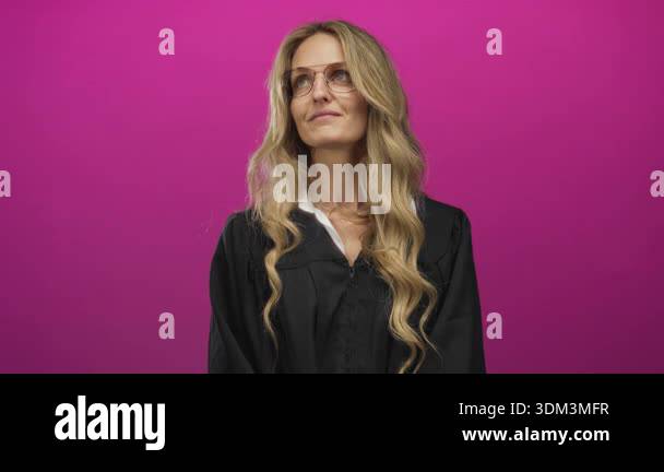 Woman judge with blonde hair in uniform standing against vibrant pink ...