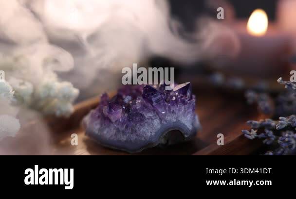 Beautiful amethyst gemstone, flowers and burning candles on table in ...