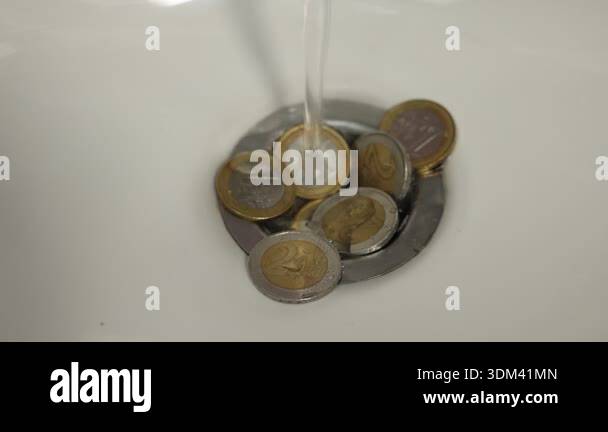 Coins and water going down sink drain, closeup Stock Video Footage - Alamy