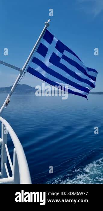 Greek flag waving above calm blue sea Stock Video Footage - Alamy